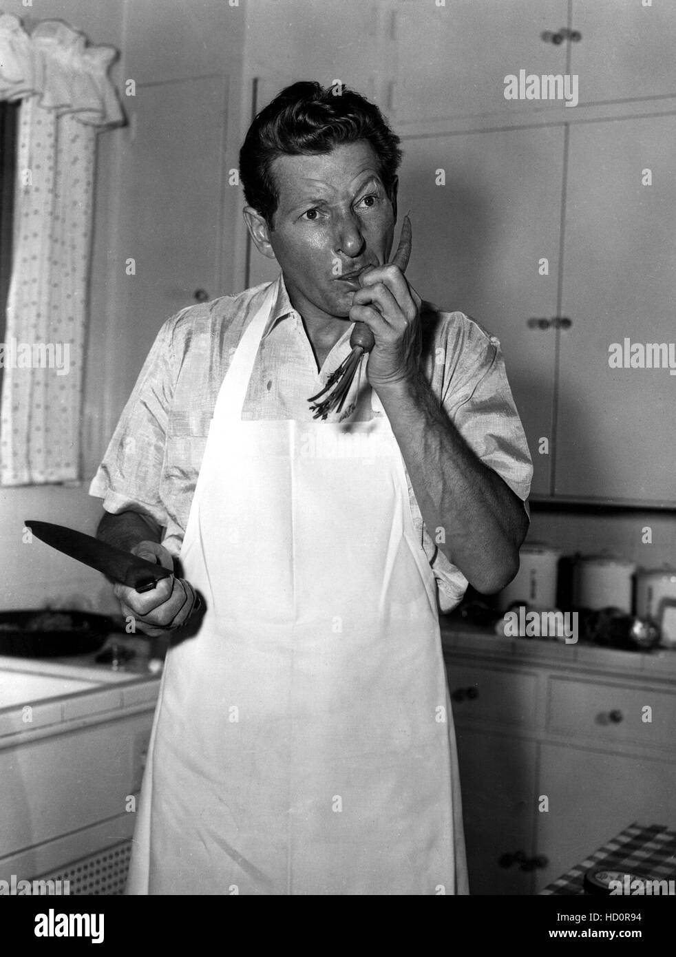 DANNY KAYE has a kitchen mishap whilst preparing a meal, 1954 Stock ...