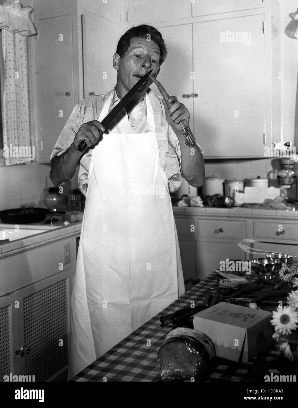 DANNY KAYE gags it up in his kitchen, 1954 Stock Photo - Alamy