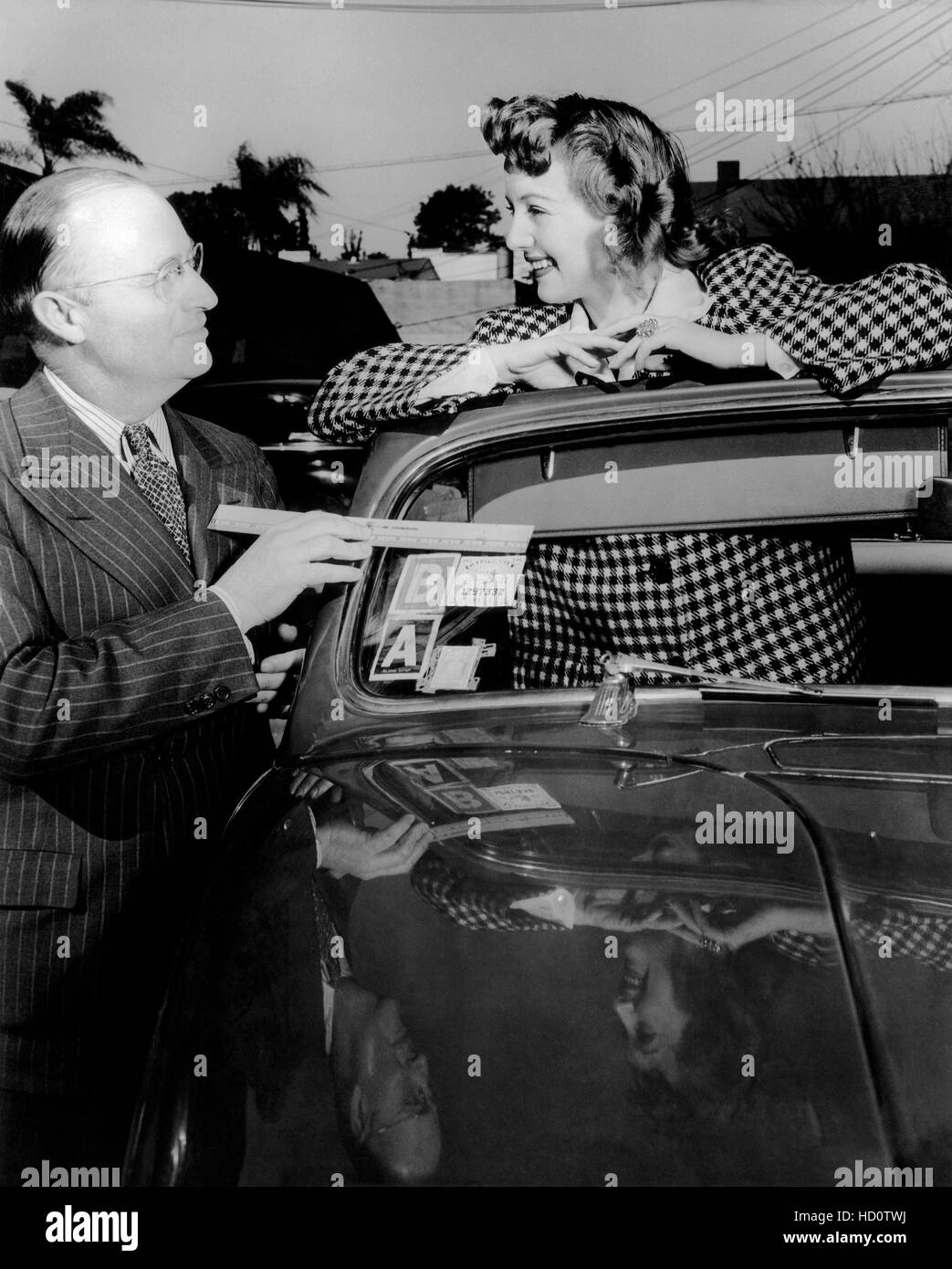 Evelyn Keyes, right, getting her gas ration sticker from Brice Clews ...