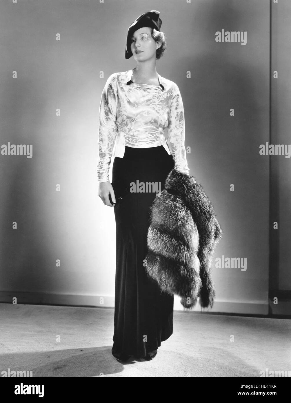 Binnie Barnes, modeling a cocktail ensamble of green brocade and velvet ...