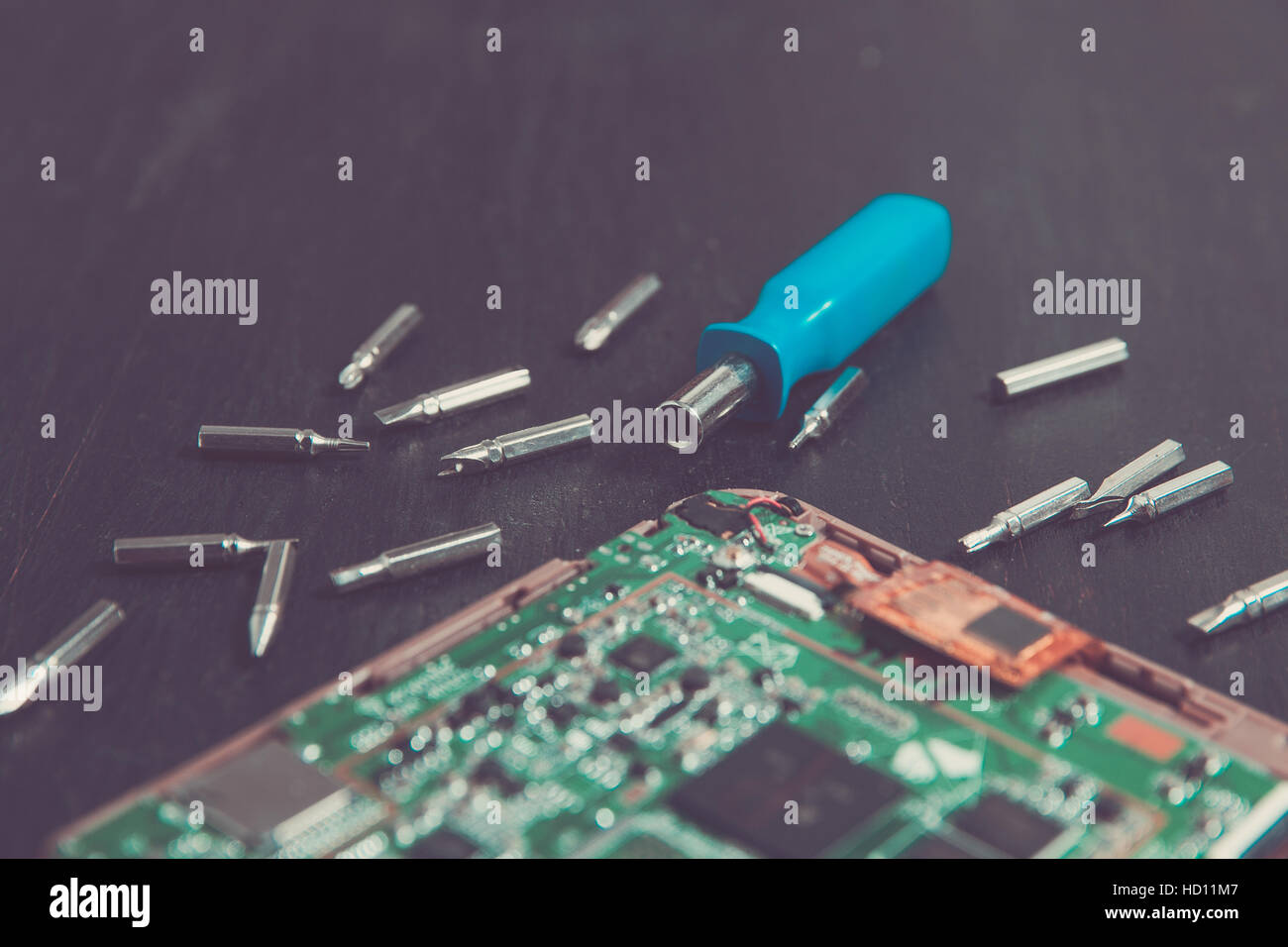 Process of PC Tablet device repair near screwdriver and bit on black ...