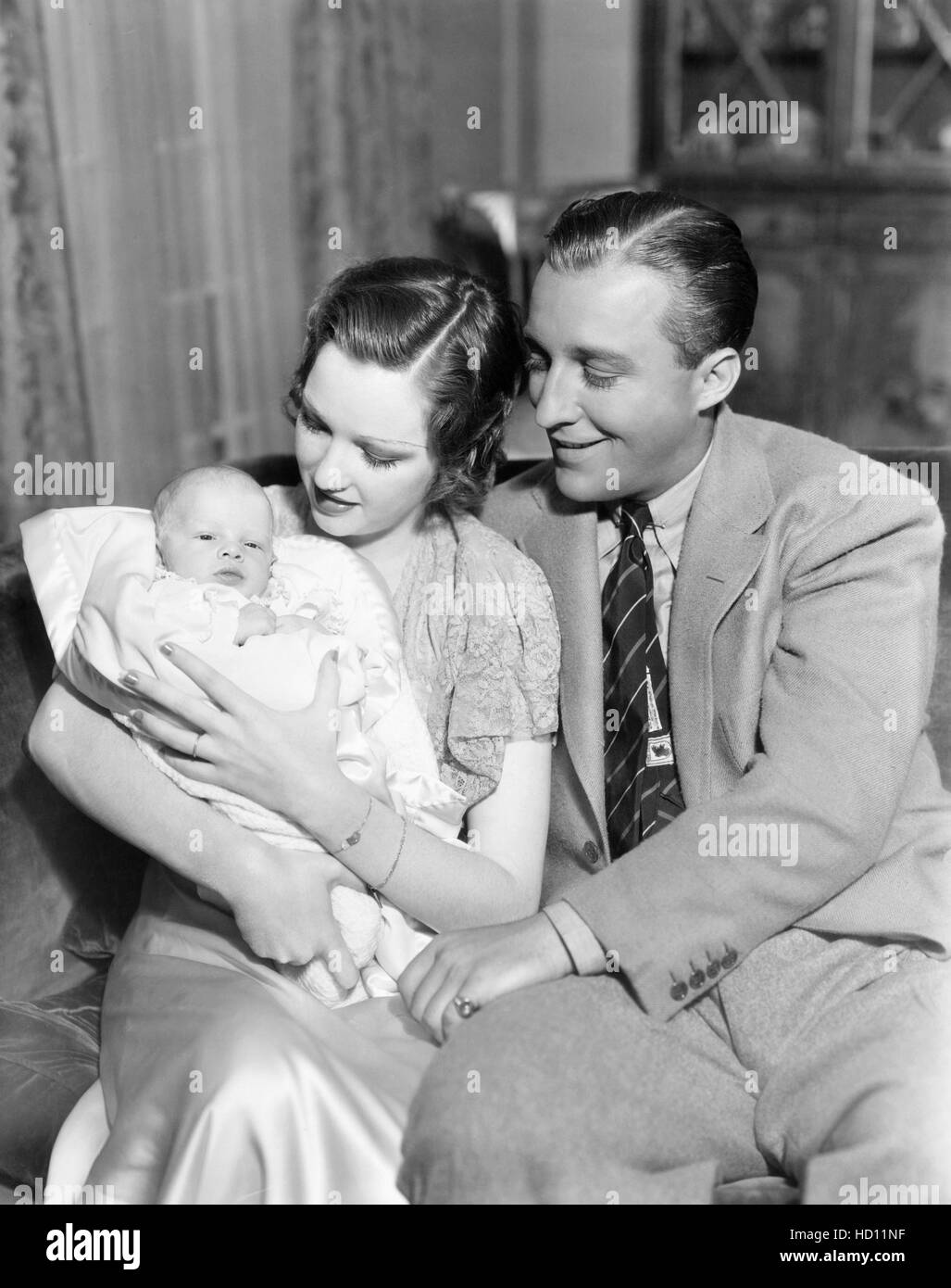 Dixie Lee holds three week old son Gary Crosby while father Bing Crosby looks on, 1933 Stock ...