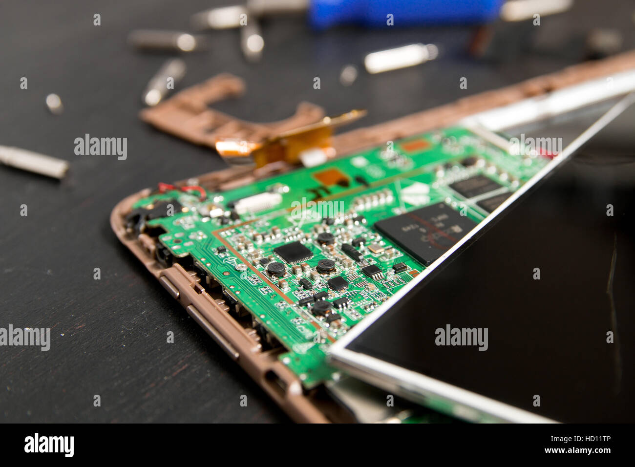 Process of PC Tablet device repair near screwdriver and bit on black ...