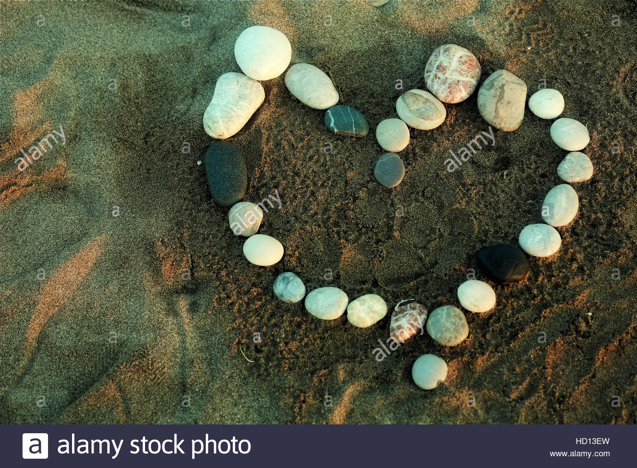 Pebbled stone love heart on a beach as Rhodes enjoys a beautiful sunset ...
