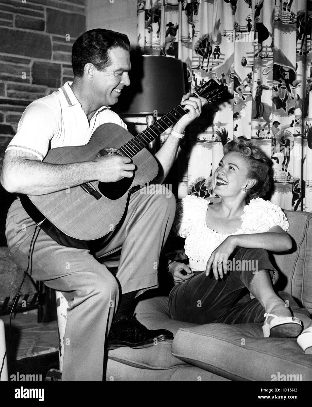 FRED MacMURRAY serenades wife JUNE HAVER during the filming of THERE'S ...