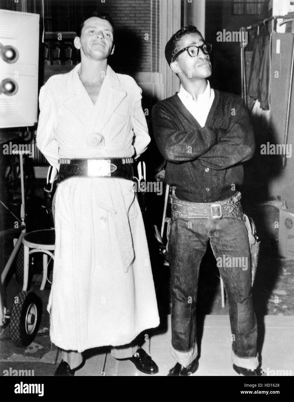 FRANK SINATRA and SAMMY DAVIS, JR. pose with western gun belts during ...