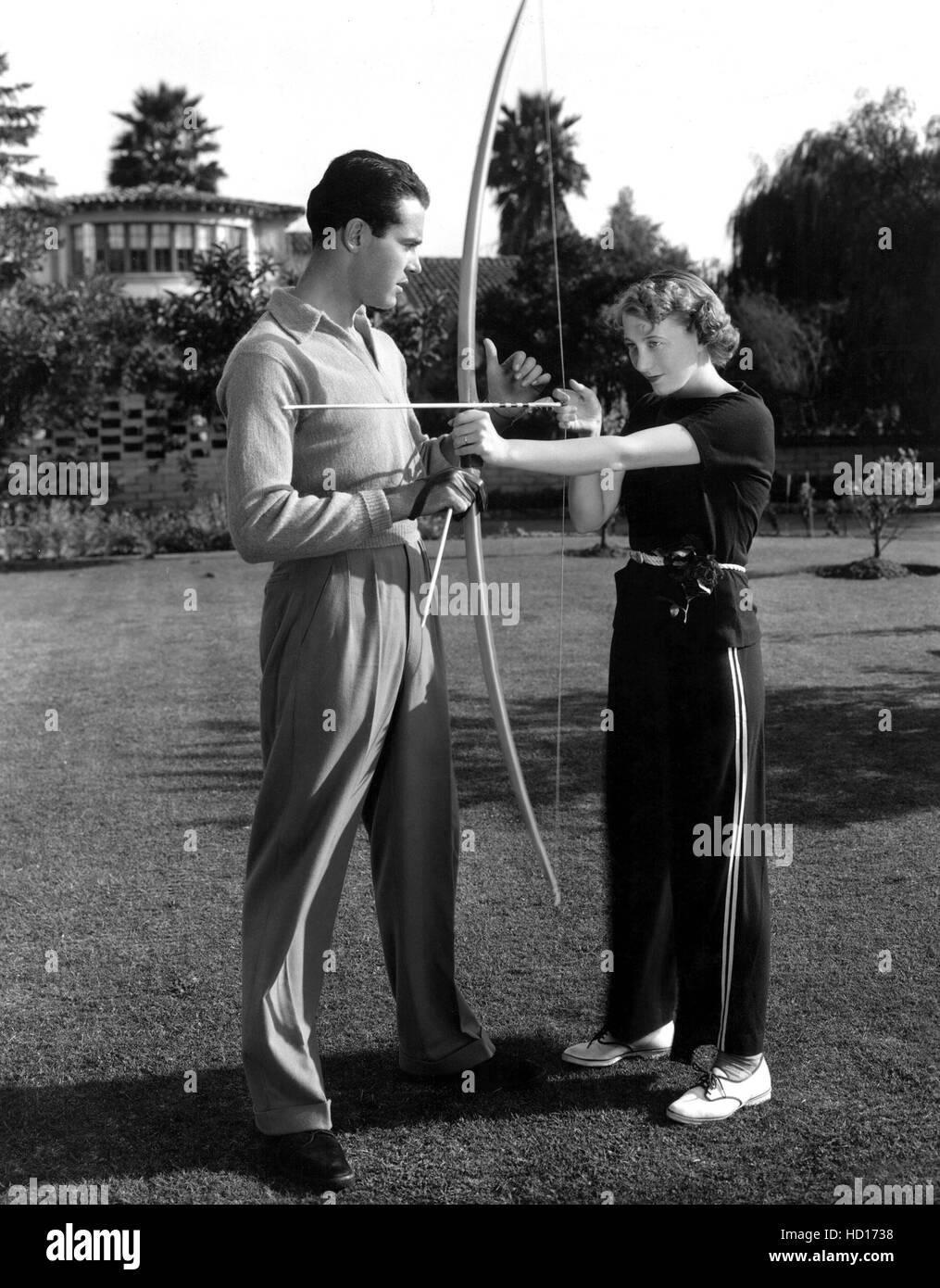 Henry Fonda instructs wife Frances Fonda in archery at their Hollywood ...