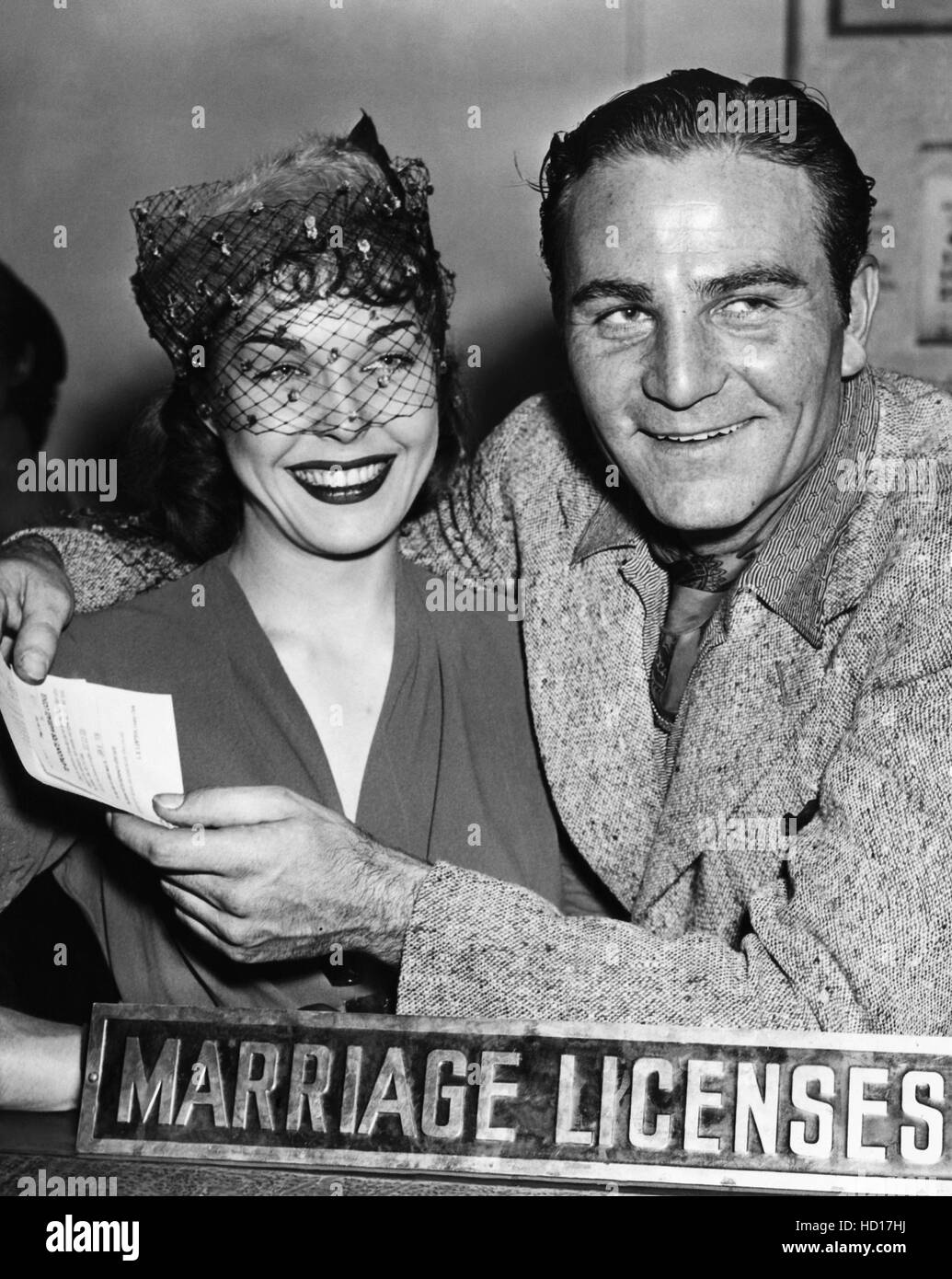 From left, Joan Woodbury, Henry Wilcoxon, applying for marriage license ...