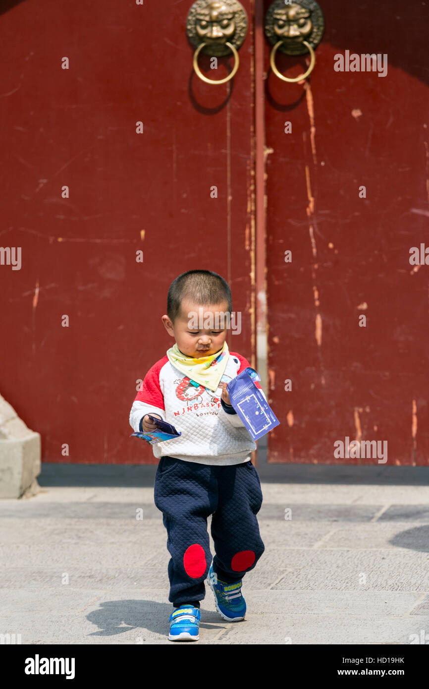 Chinese boy playing at entrance door to Xian city walls, Shaanxi, China ...