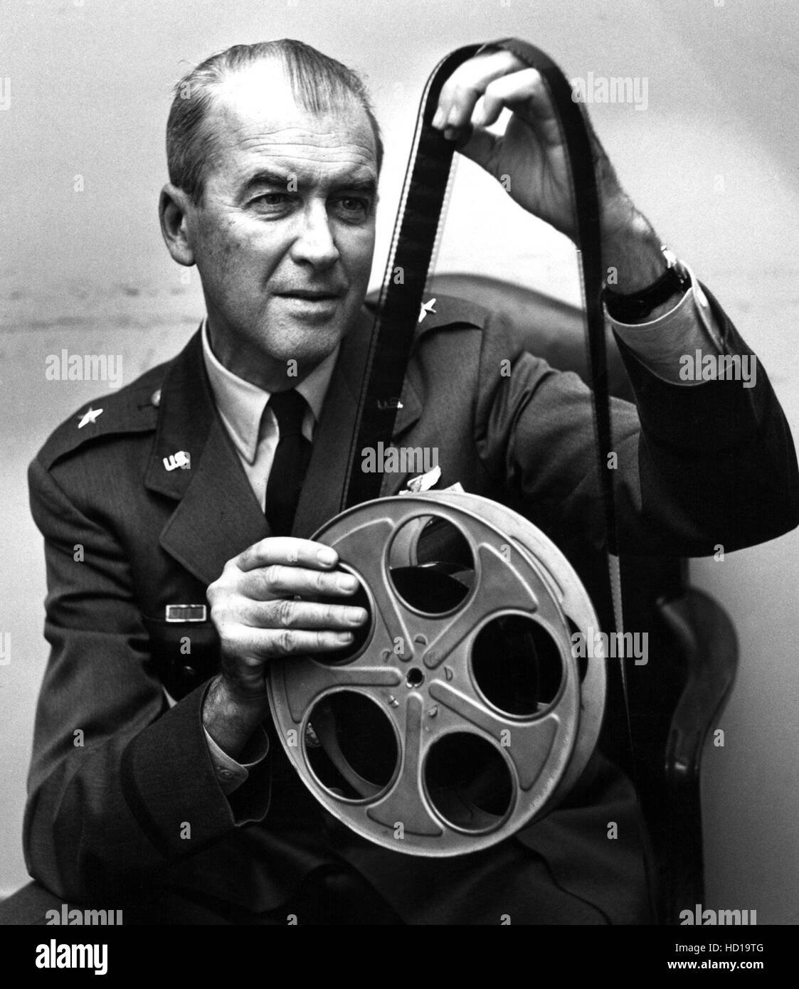 BRIGADIER GENERAL JAMES STEWART examines a reel of troop information ...