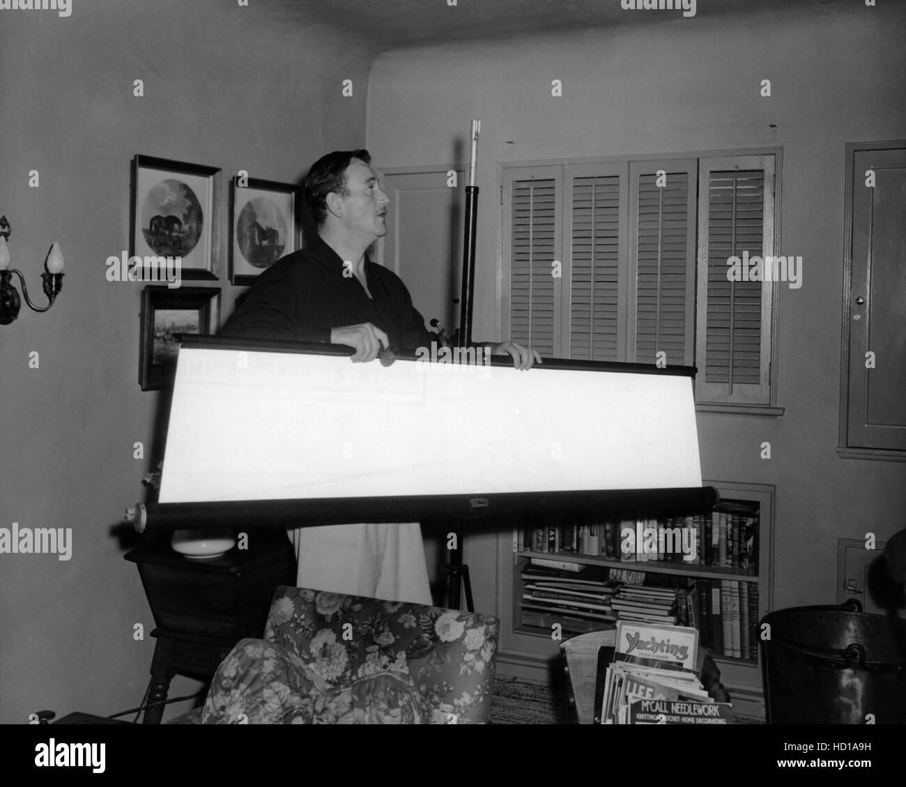 John Wayne, setting up home-movie screen, 1949 Stock Photo - Alamy