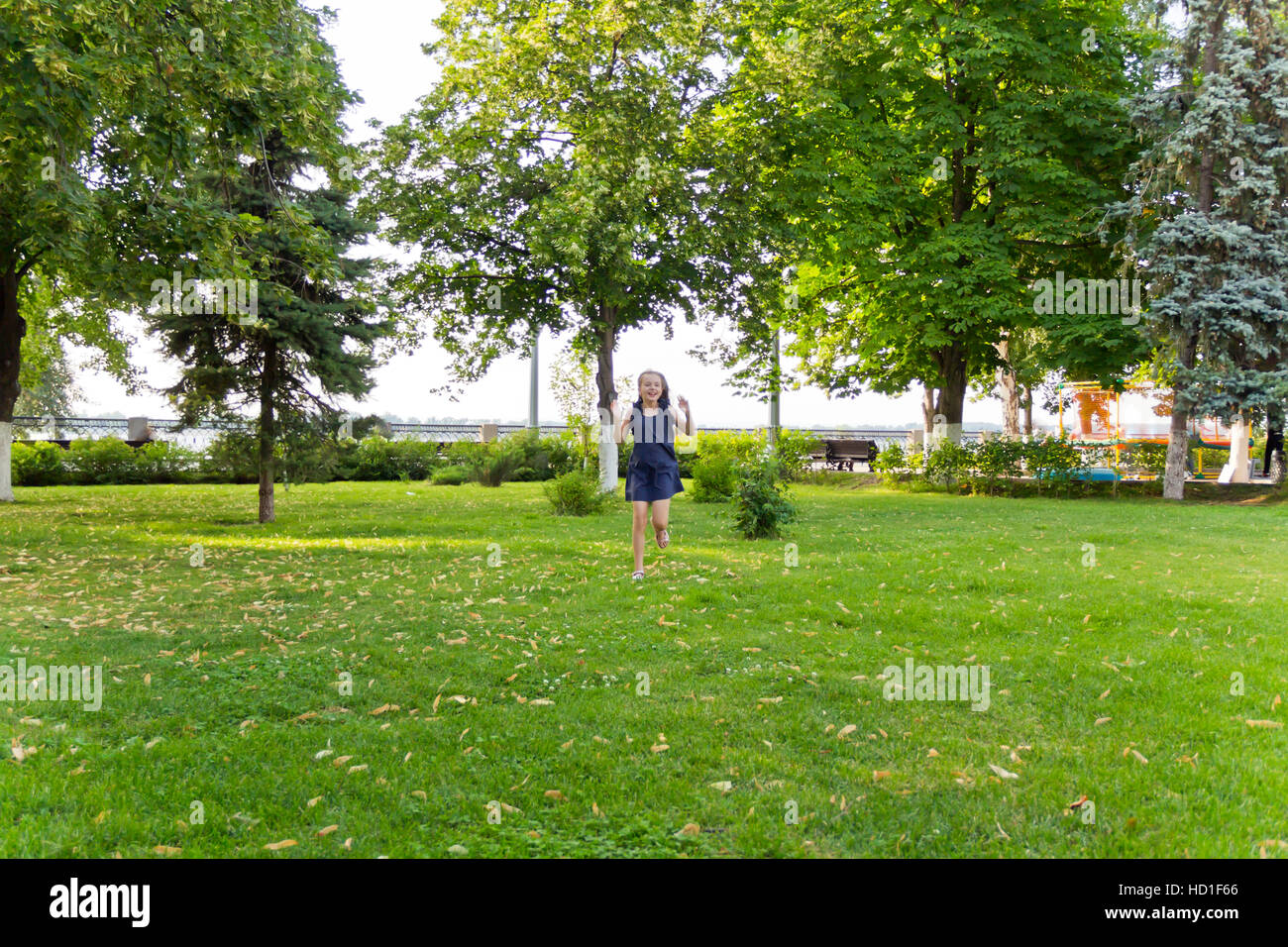 Girl is running in park on green grass Stock Photo - Alamy