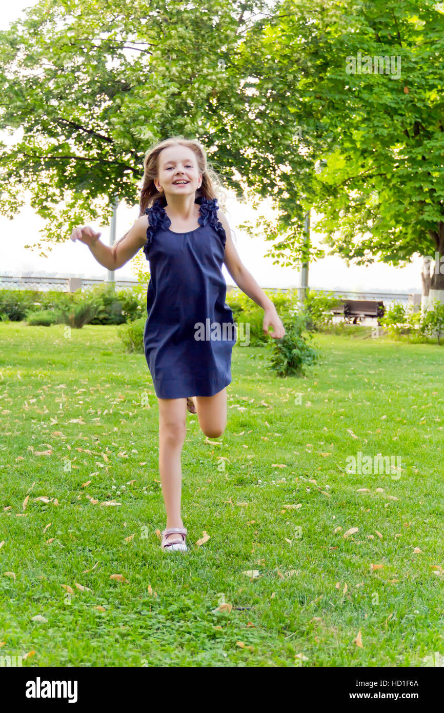 Girl is running in park on green grass Stock Photo - Alamy