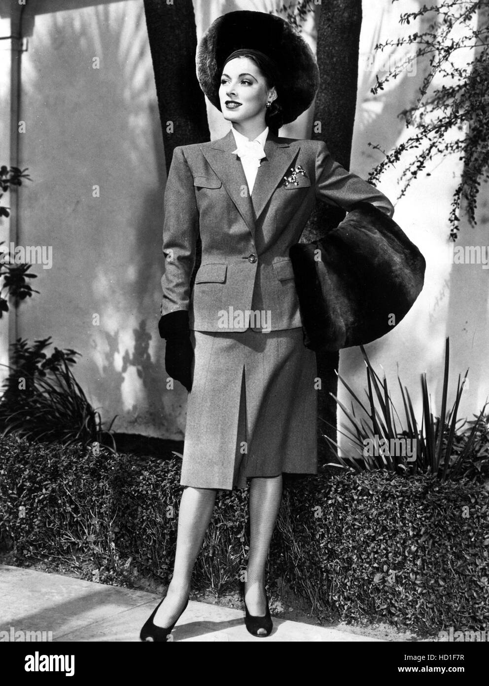 ELEANOR PARKER wearing a gray flannel suit with a beaver beret and muff ...