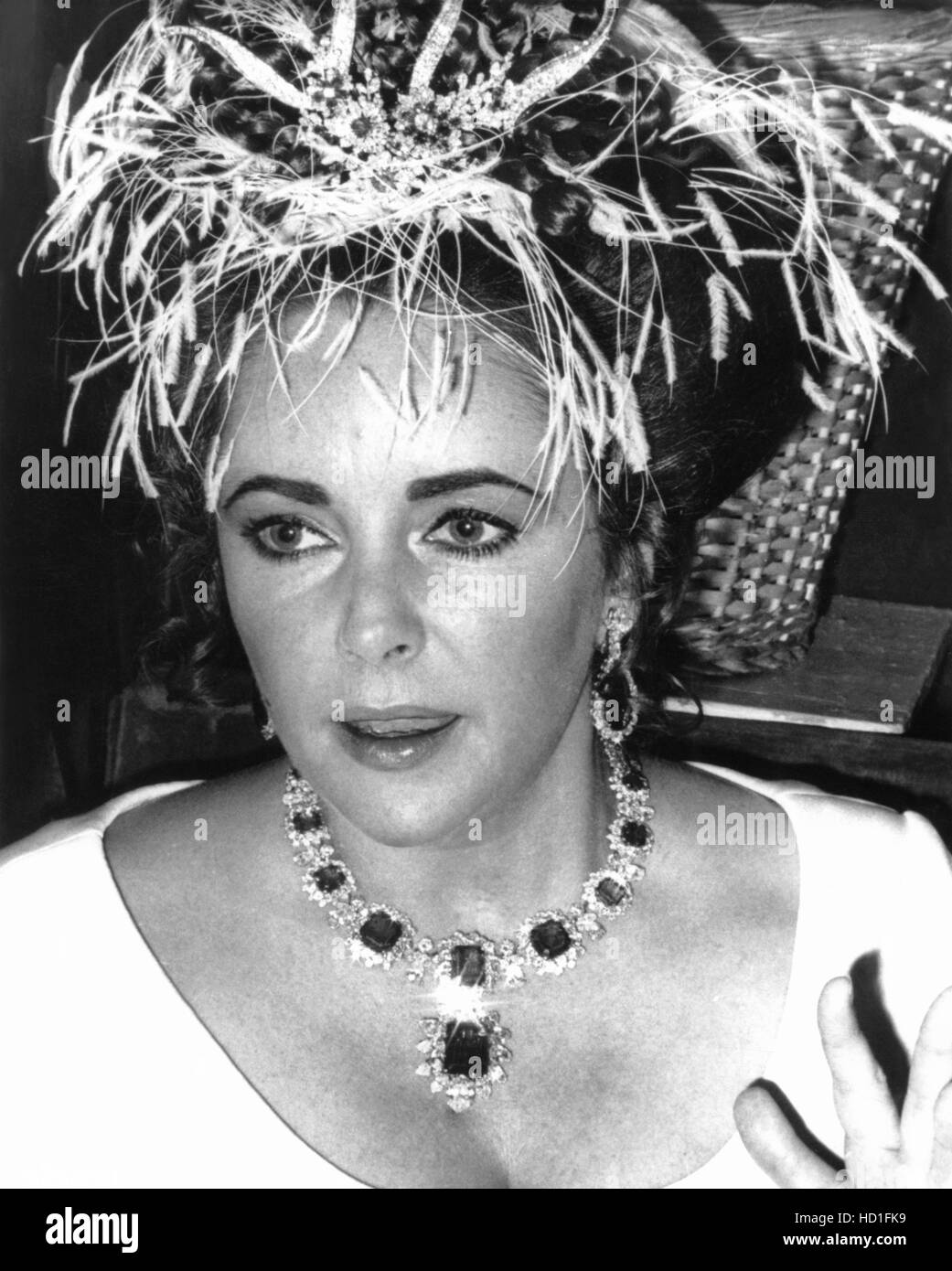 Elizabeth Taylor, in an ostrich-feather hat and diamond and emerald ...