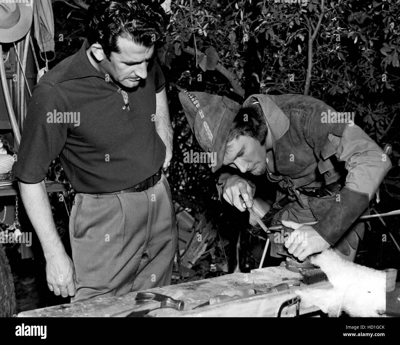 Archery expert HOWARD HILL gives star ERROL FLYNN some pointers during ...
