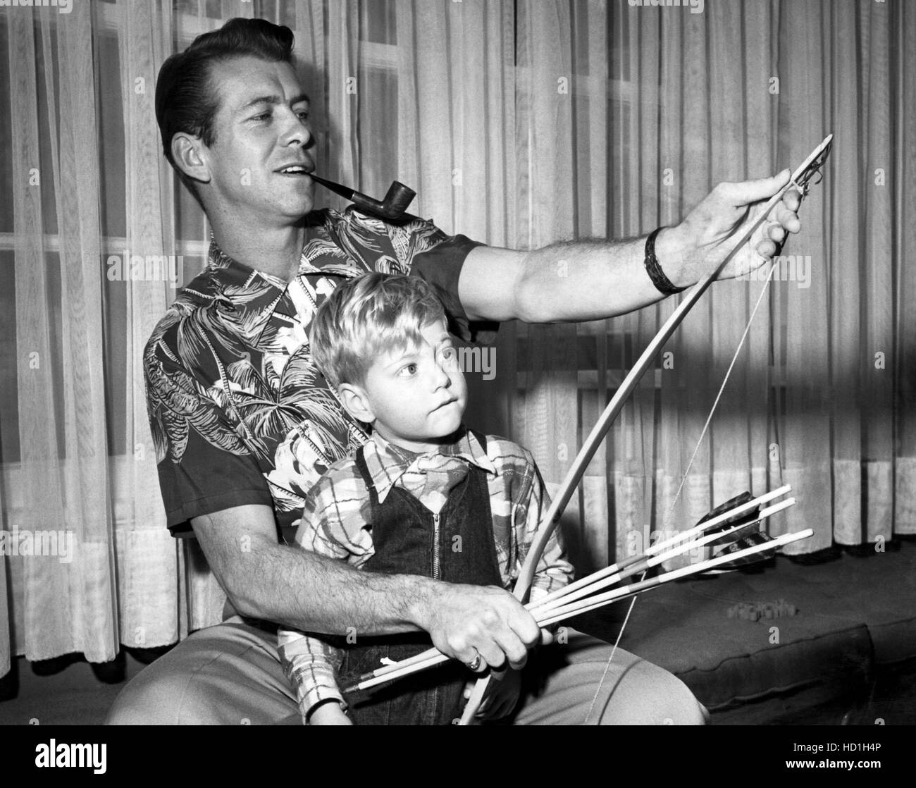 From left: Gene Nelson, son Christopher Nelson playing with archery set ...