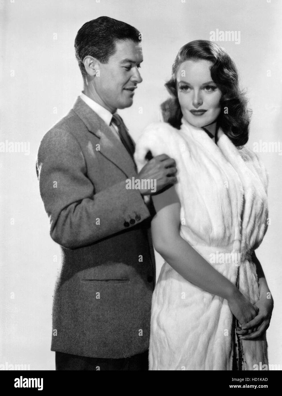 Clothing designer Jean Louis with Dorothy Hart who is wearing an ermine ...