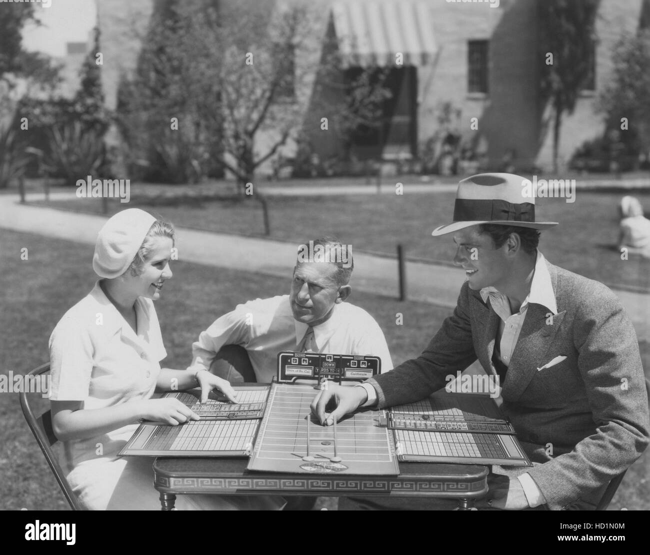 June Clyde (left) and Joel McCrea (right) playing a football board game ...