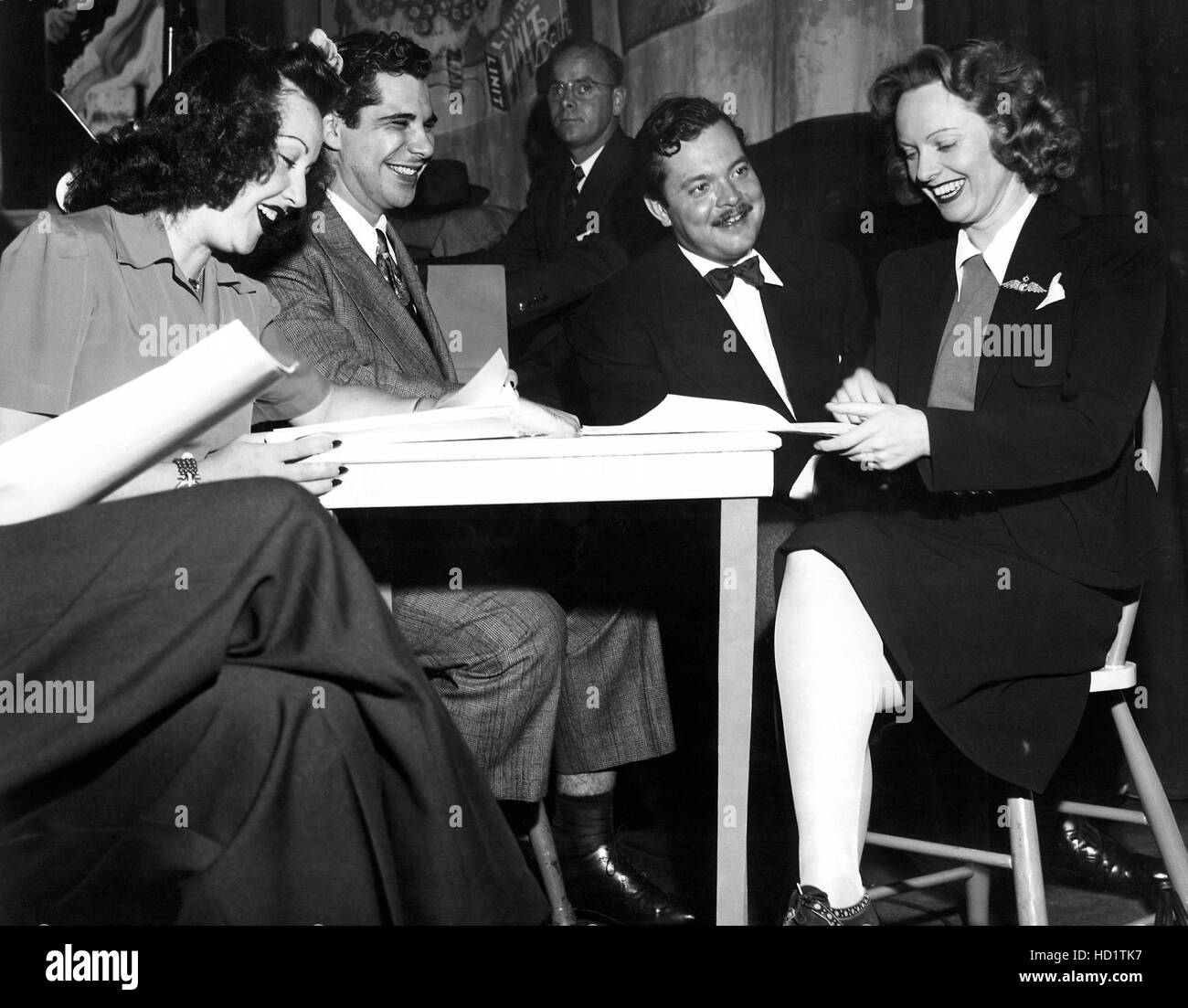 Orson Welles, Anna Neagle laugh with production personnel while ...