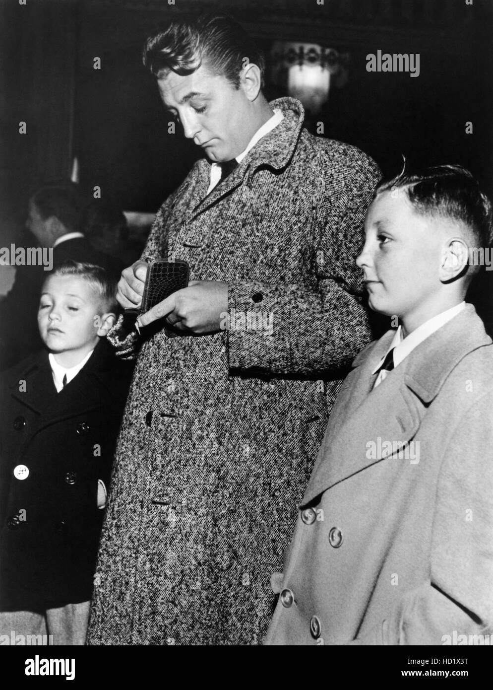 Robert Mitchum signing an autograph flanked by his sons Christopher ...