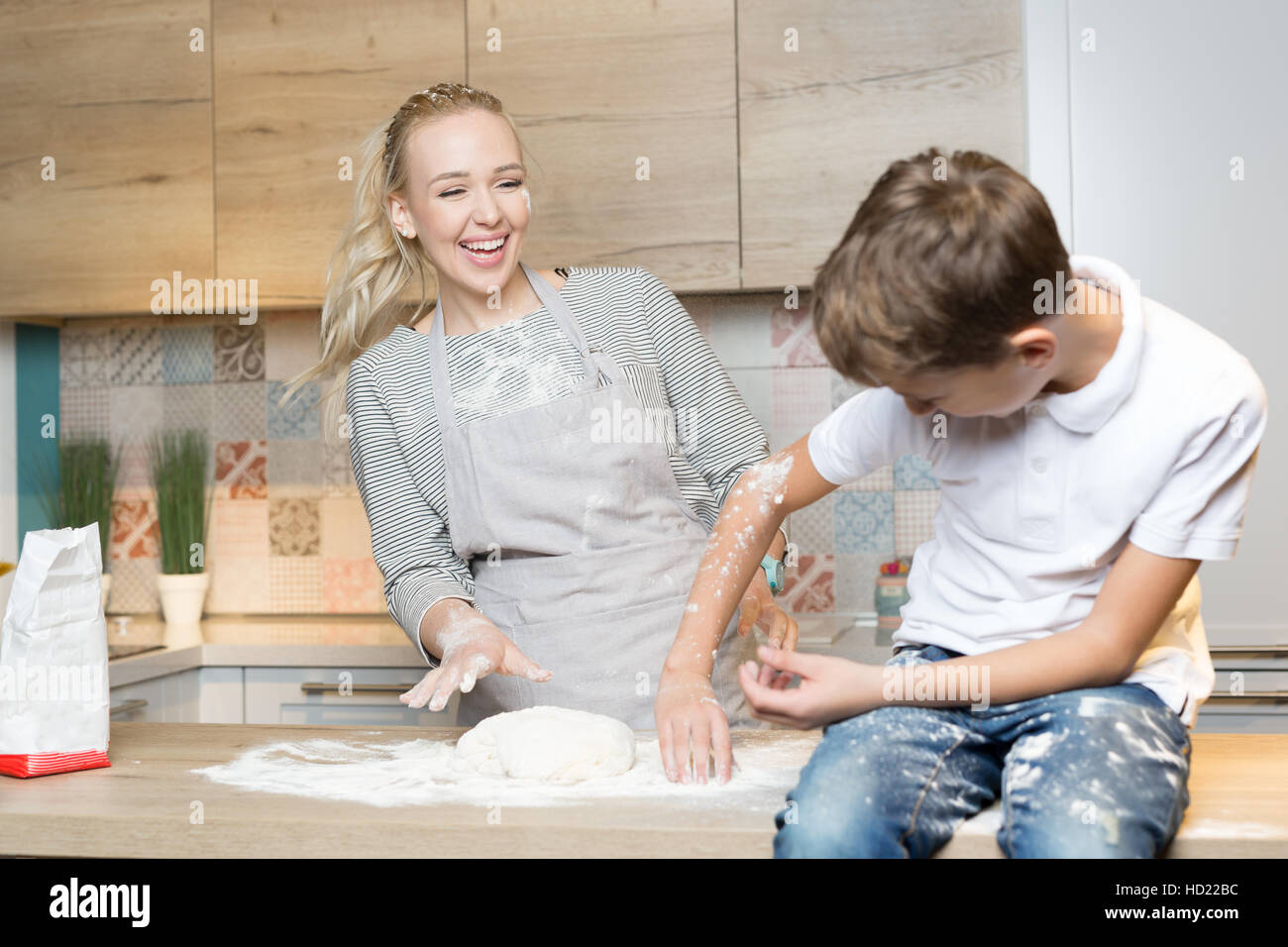 mother and son playing in kitchen with flour, flour fight Stock Photo ...