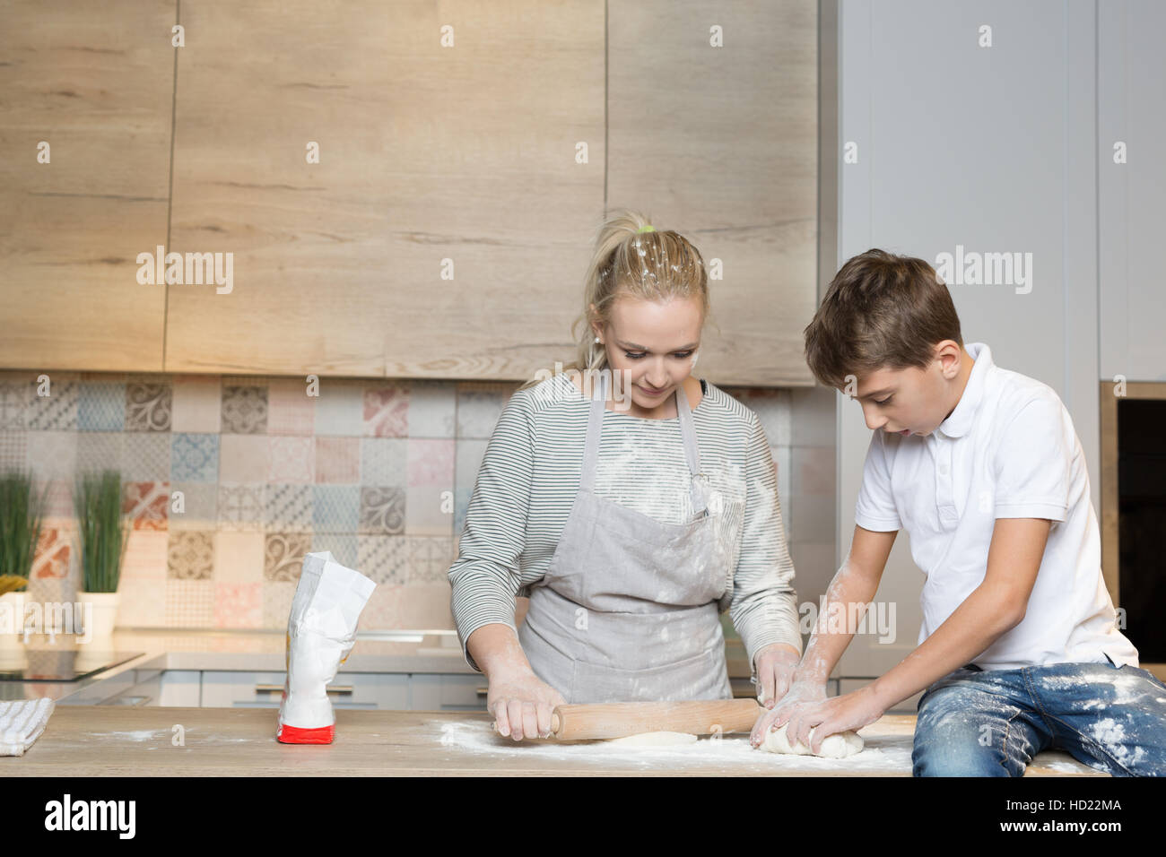 Smiling mother cooking with her son in kitchen at home Stock Photo - Alamy