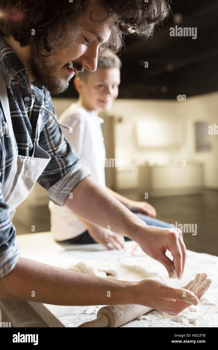 Flour fight in kitchen. Father and his son preparing a cake in the ...