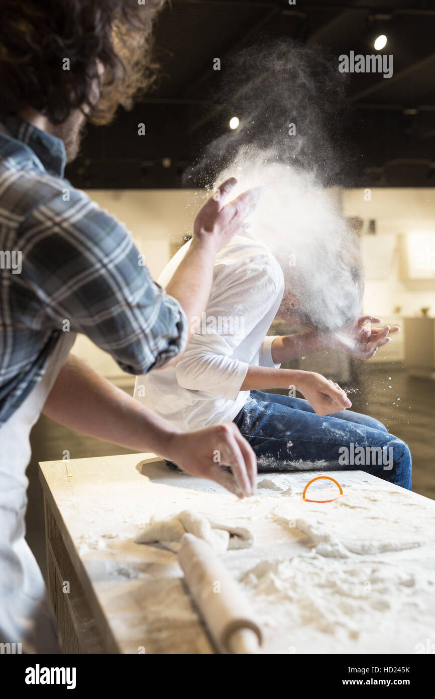 Flour fight in kitchen. Father and his son preparing a cake in the ...