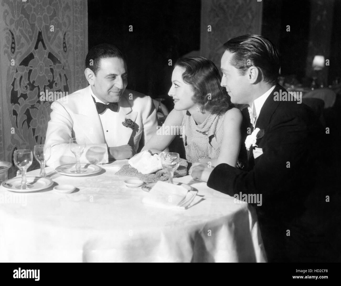 Joan Crawford (center), with her husband Franchot Tone (right), facing ...