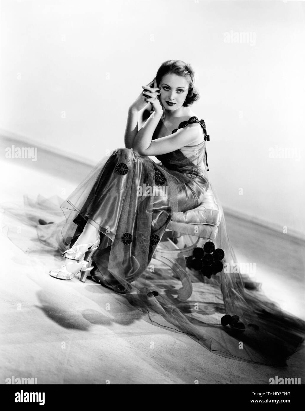 June Lang wears a scarlet satin evening gown with a net overlay ...