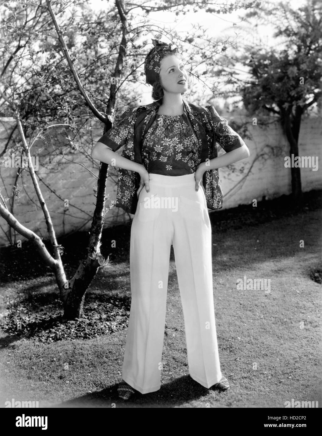 June Lang poses in tailored white linen slacks with Tyrolean inspired ...