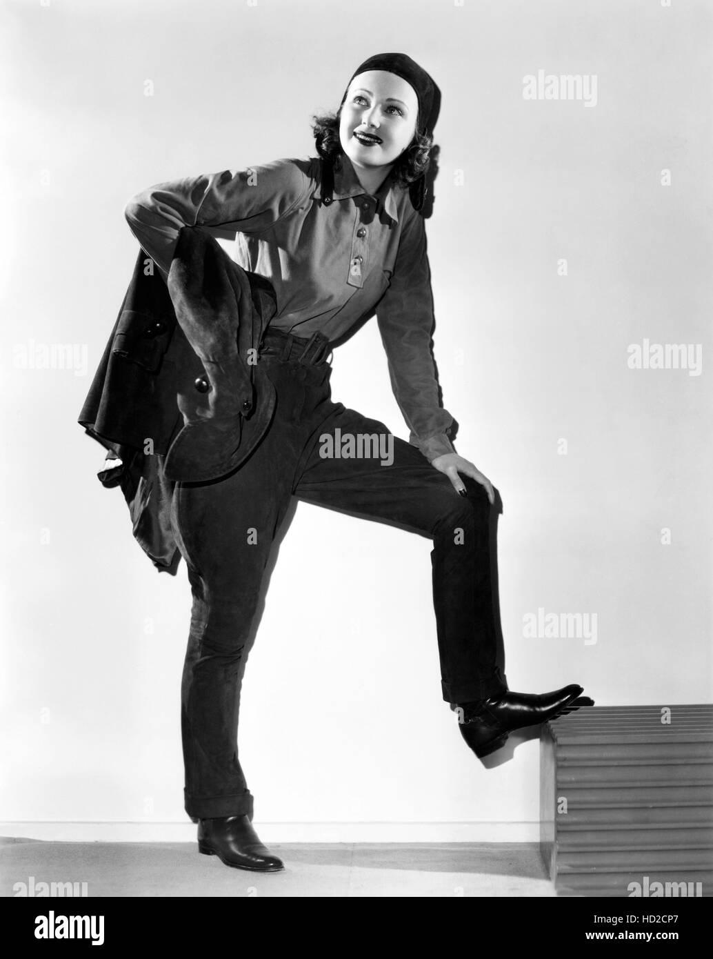 June Lang wears flying togs - brown suede pants and a sand-colored ...
