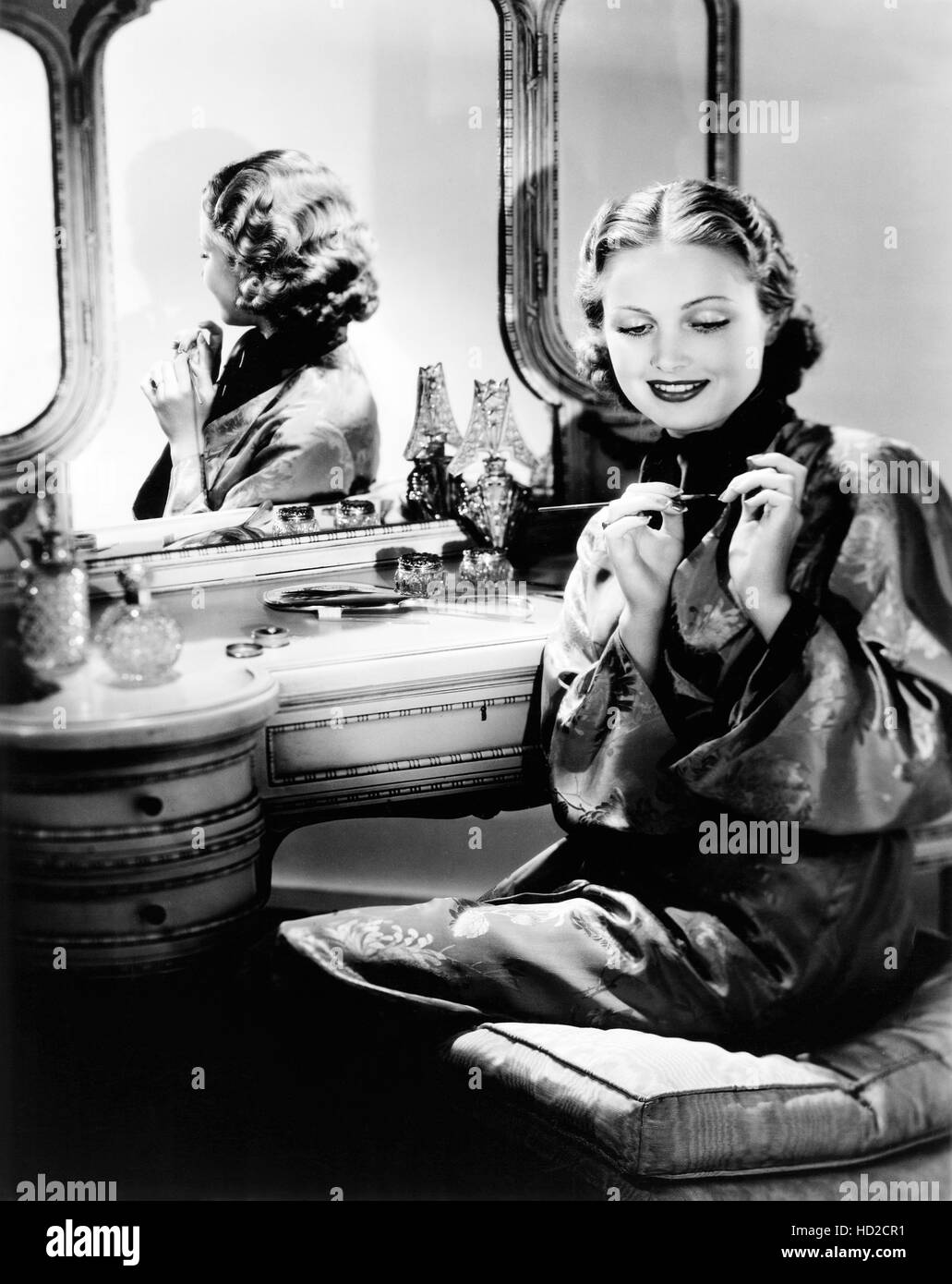 June Lang uses a fine camel's hair brush to apply geranium red nail ...