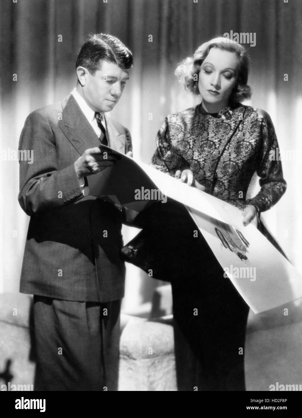 Costume designer Travis Banton showing sketches to Marlene Dietrich, ca ...
