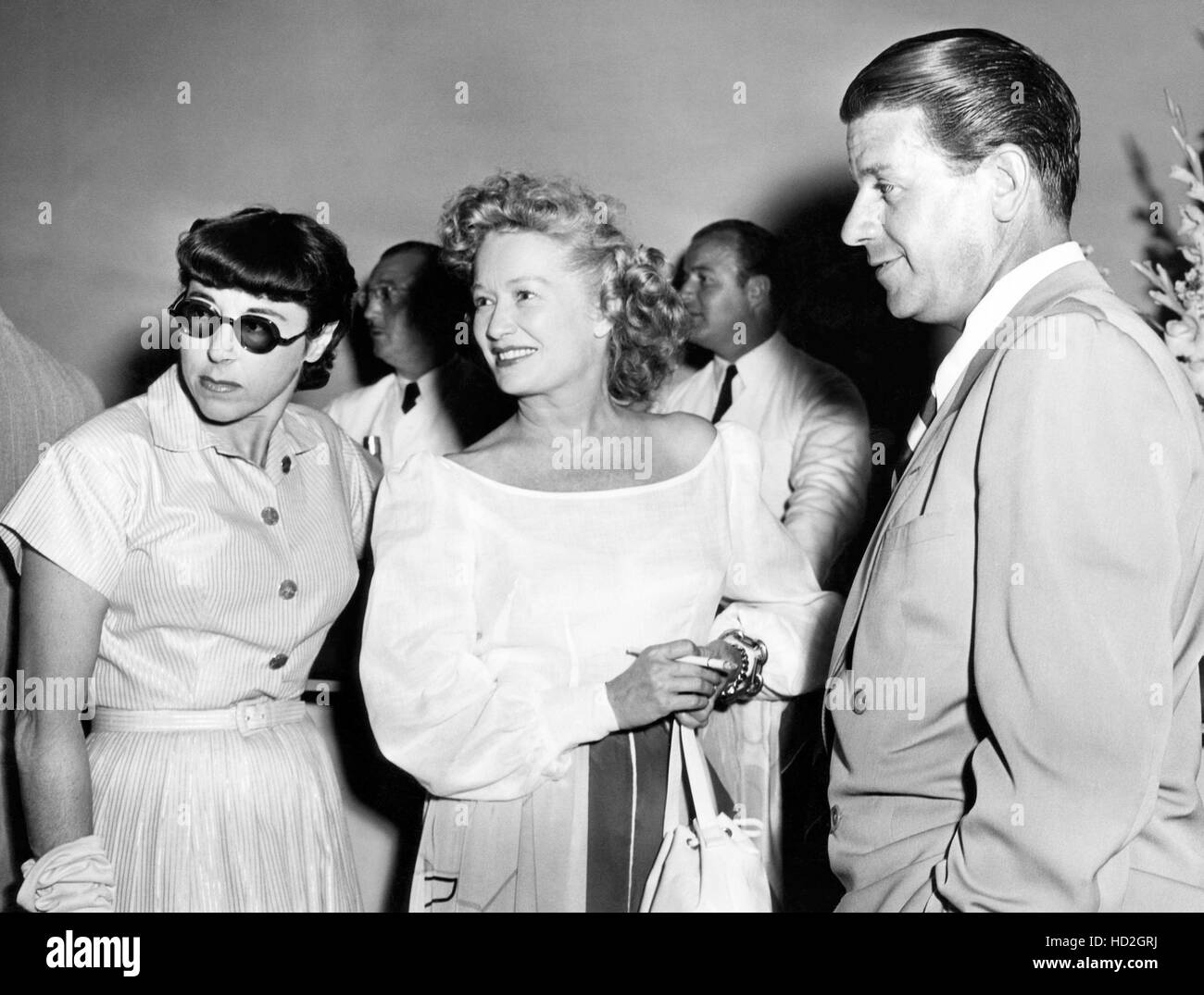 Edith Head, Miriam Hopkins, director, Compton Bennett at cocktail party ...