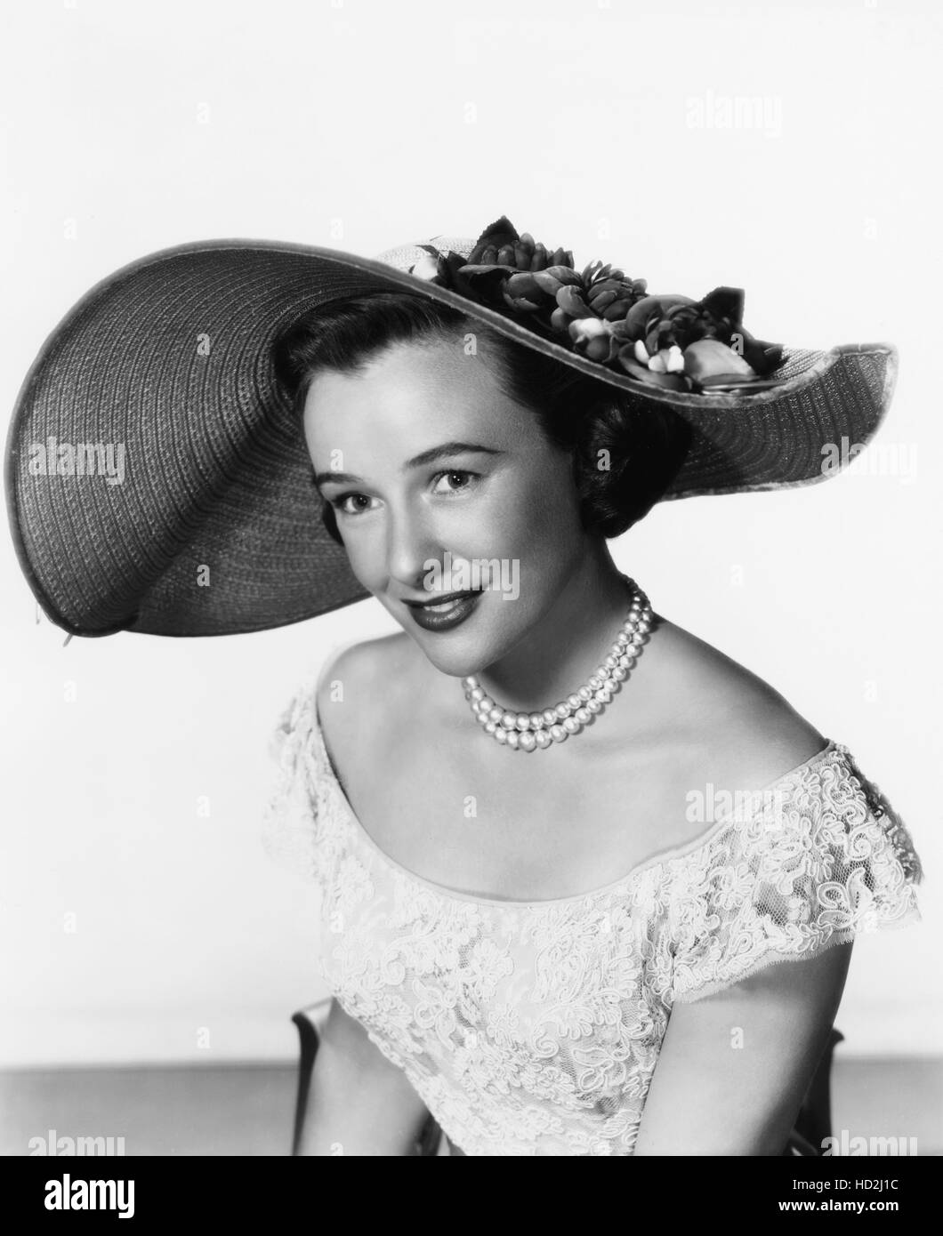 Phyllis Thaxter, modeling an Italian braid hat trimmed with red velvet ...