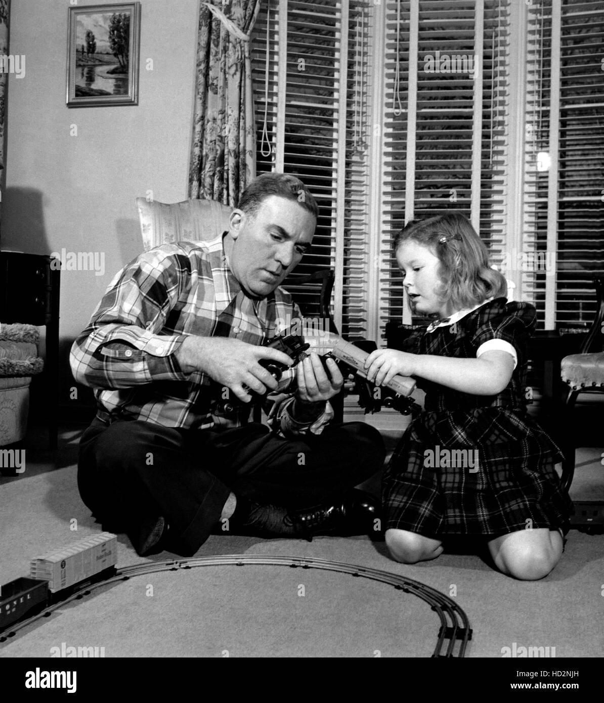 From left: William Bendix and daughter, Stephanie, playing with train ...