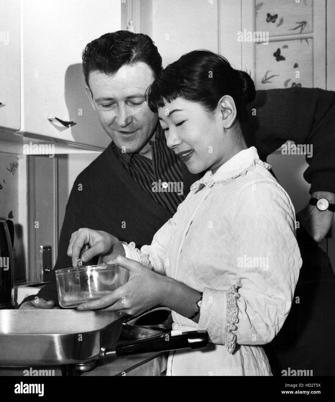 Miyoshi Umeki cooks scrambled eggs for her husband Frederick Opie, New ...