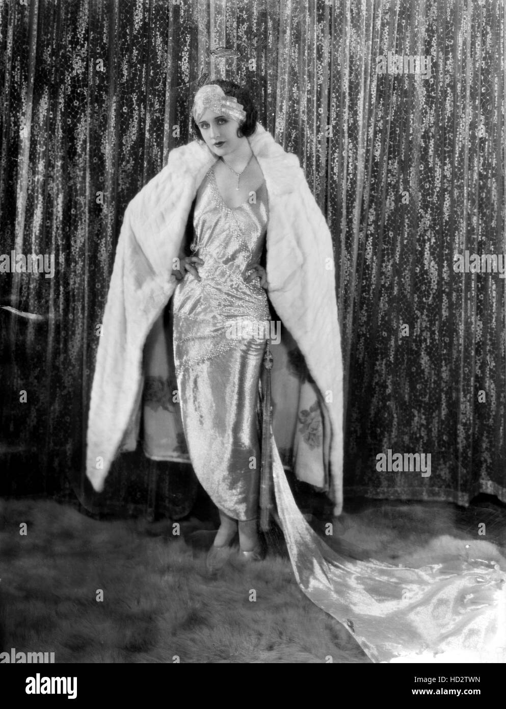 Norma Shearer, modeling a white ermine coat over a silver cloth gown ...