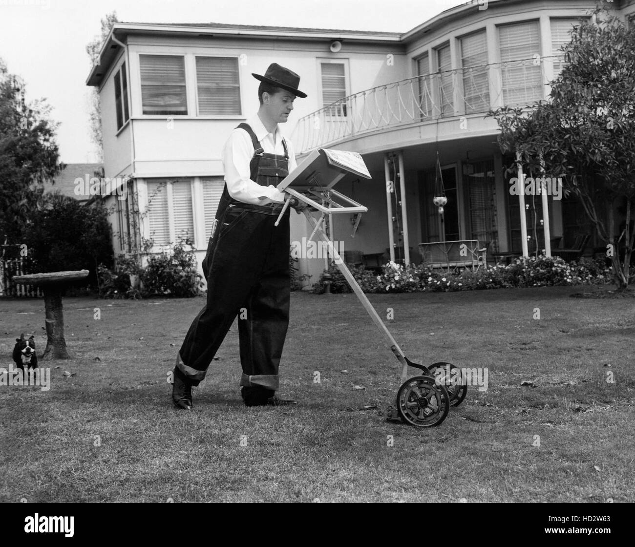 A multi-tasking Red Skelton, mowing the lawn while reading his paper ...