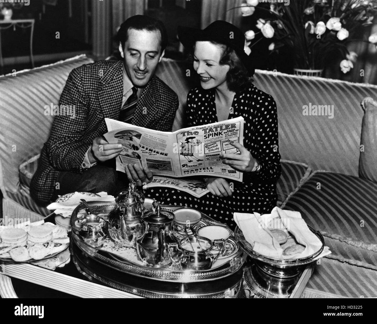 from left: Basil Rathbone and Wendy Barrie reading The Tatler, circa ...