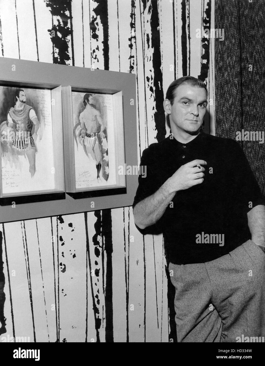 Actor Stanley Baker poses in his home beside several pieces in his ...
