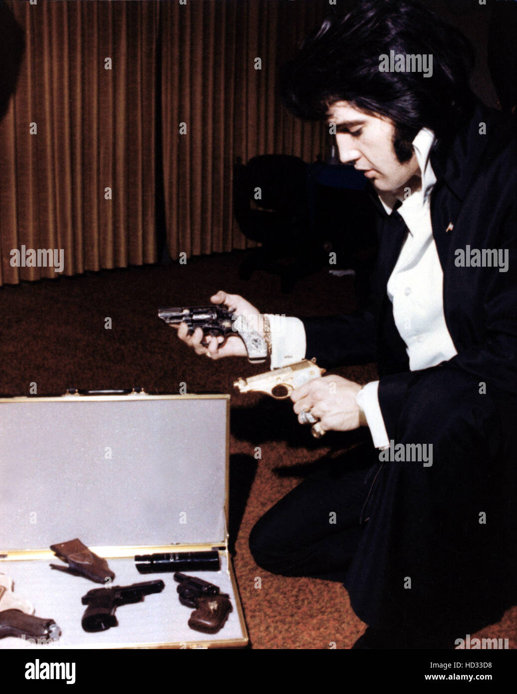 ELVIS PRESLEY and examines a collection of guns Stock Photo - Alamy