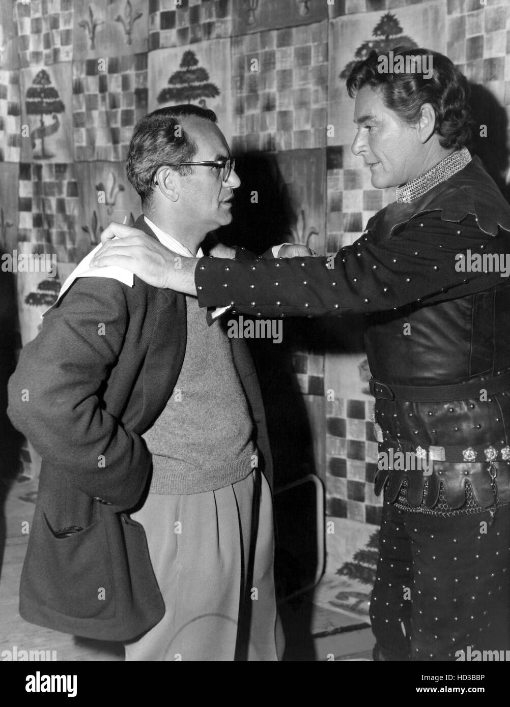 From left: director Henry Levin and star Errol Flynn confer between ...