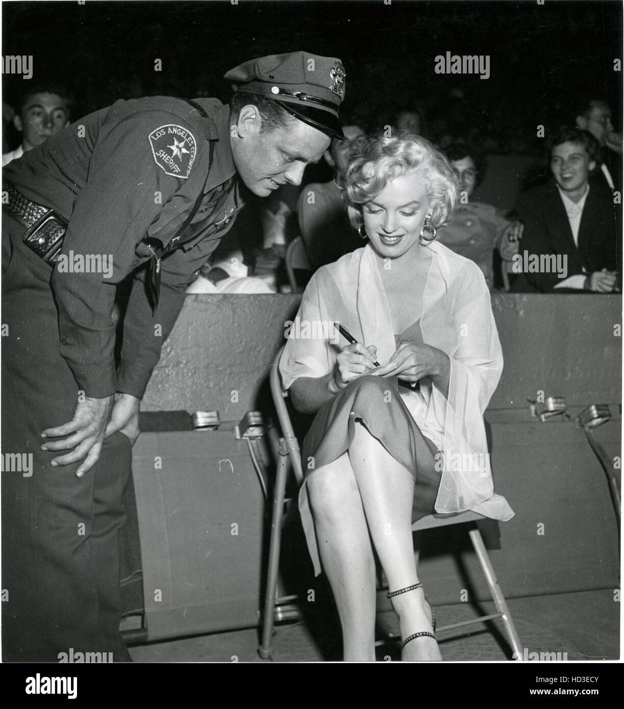 Marilyn Monroe signs an autograph for a policeman at singer Ray Anthony ...