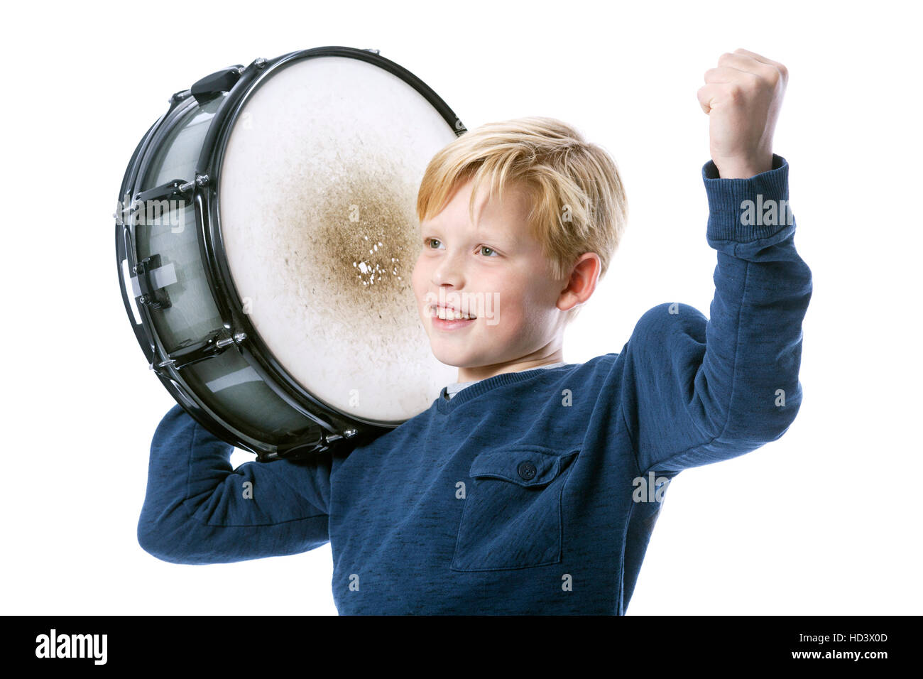young blond boy with drum against white background in studio shows ...