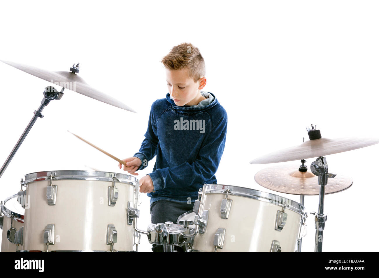 teenage boy behind drum kit in studio against white background Stock ...