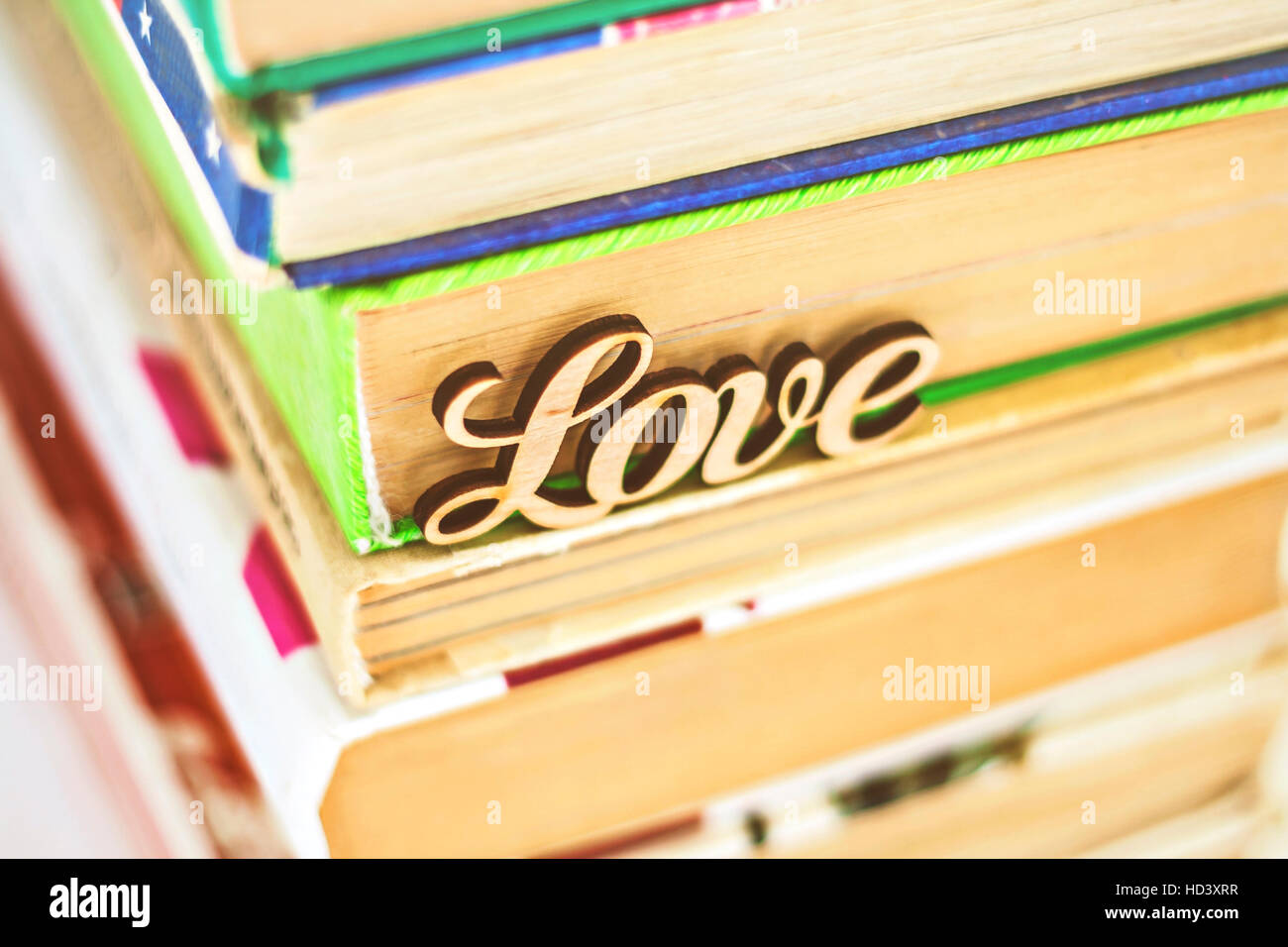 on a stack of old books wooden word love Stock Photo - Alamy