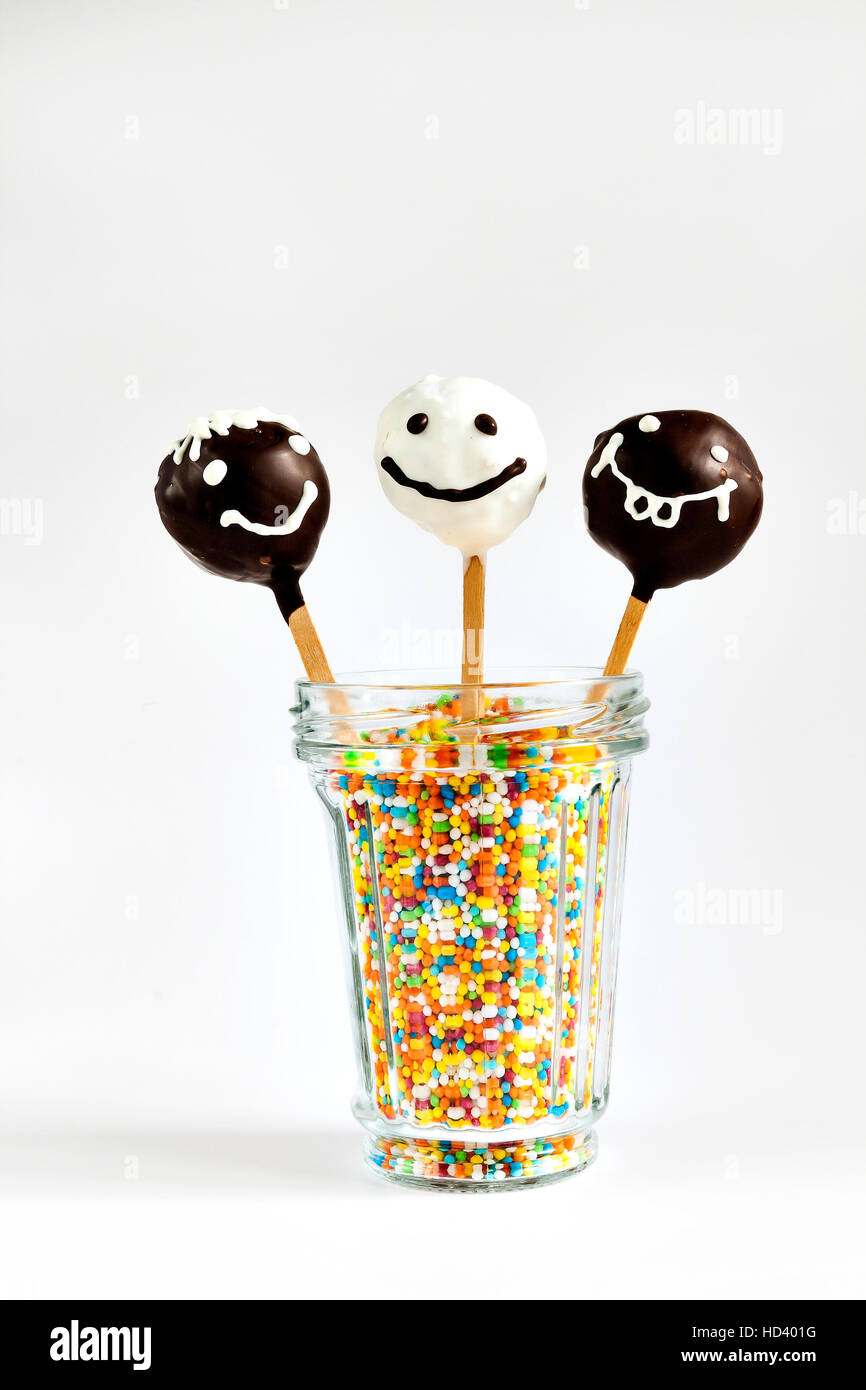 three cake pops with painted smiles isolated Stock Photo - Alamy